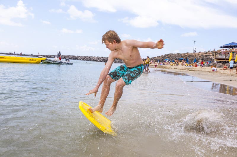 Boy Jumps into the Ocean with His Boogie Board Stock Image - Image of ...