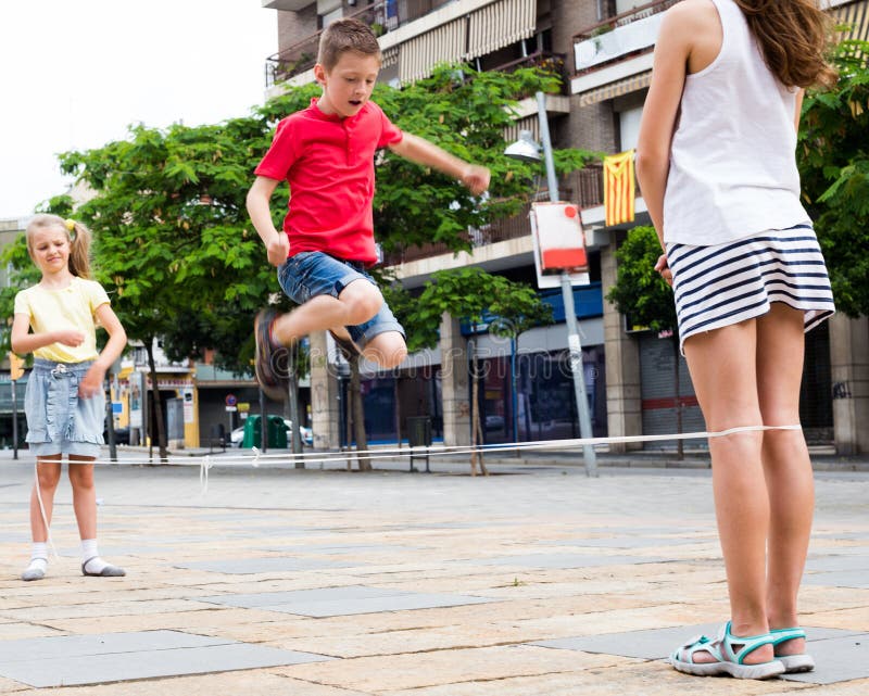 Boy Jumps Over the Rope on the Sidewalk in the City in Summer Stock ...