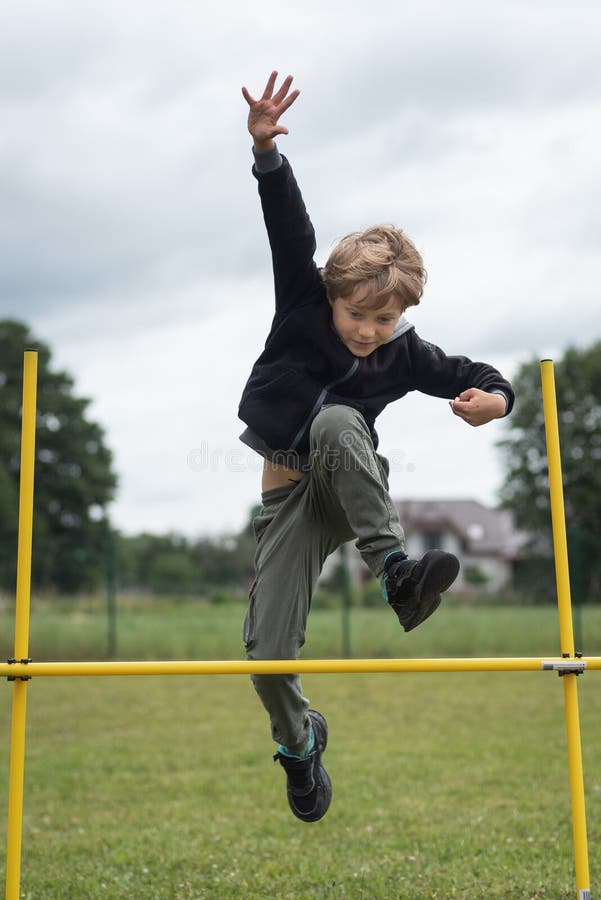 Boy Jumps Up Over the Obstacle Stock Photo - Image of exercise, blonde ...