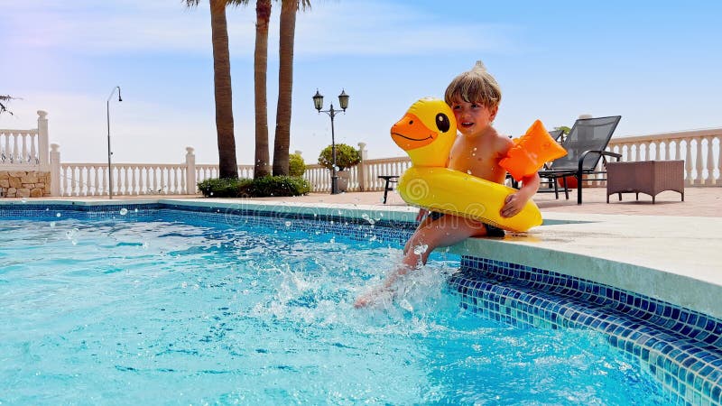 Boy Kid Splashes with Legs at Pool in Floaty, Under a Sunny Sky Stock ...