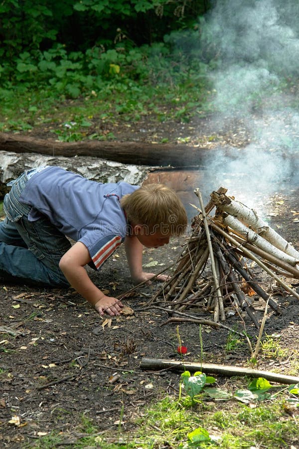 Boy kindles bonfire stock photo. Image of forest, person - 2597074