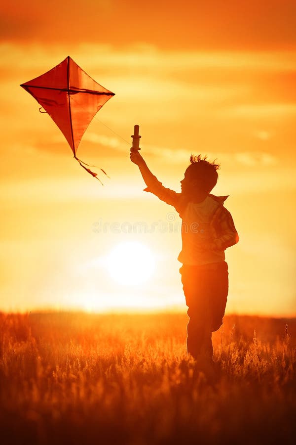 Boy with a kite at sunset stock image. Image of leisure - 216914413