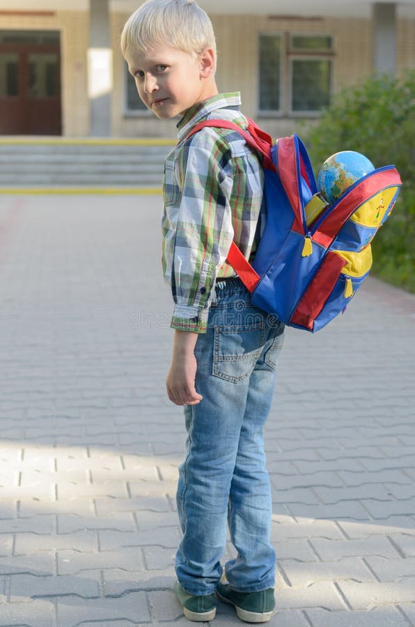 A Boy with a Knapsack, Books and a Globe Goes To School after a Long ...