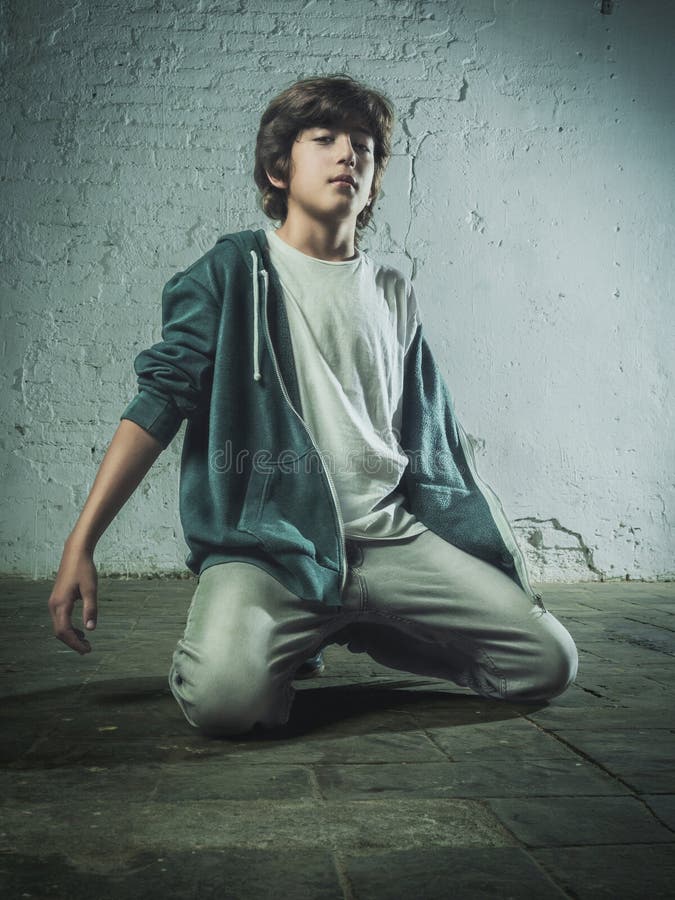 Boy Kneeling on the Ground in a Defiant Pose in Front of the Camera ...