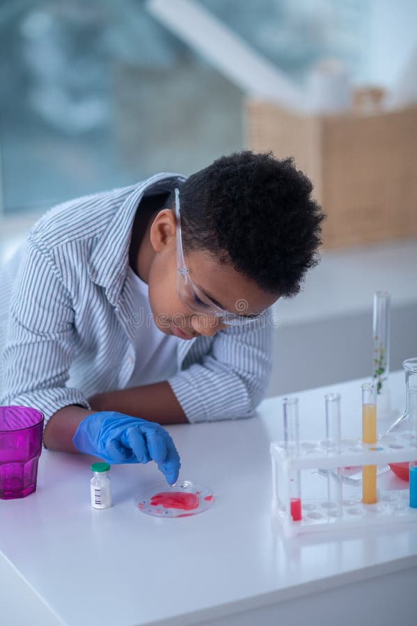 A Boy in a Lab Coat Working with Test Tubes and Looking Involved Stock ...