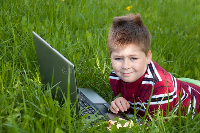 Boy with Laptop Computer Lying on the Grass Stock Photo - Image of ...