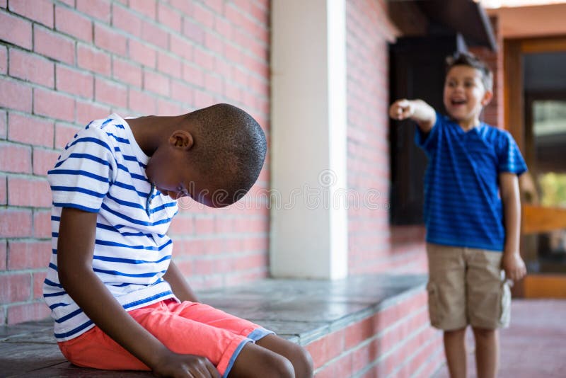 Boy Laughing on Sad Classmate in Corridor Stock Image - Image of ...