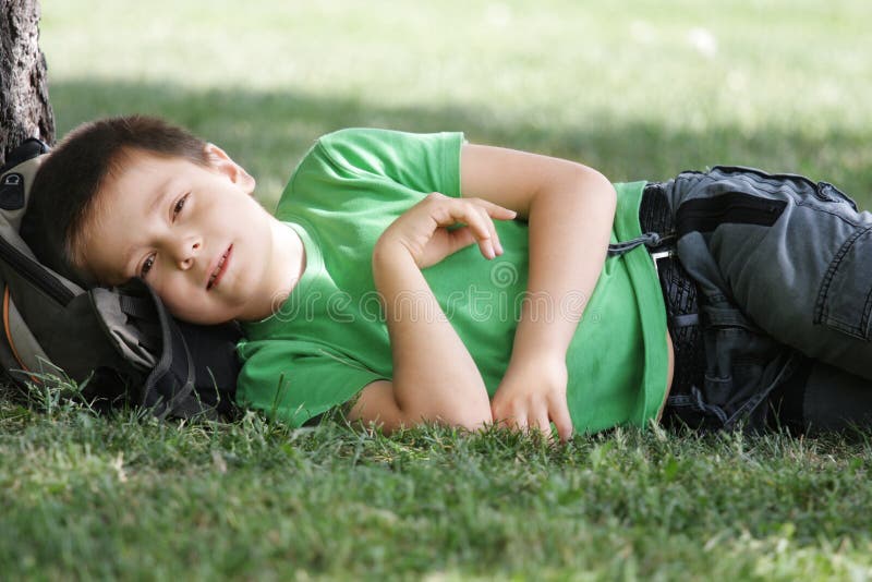 Boy laying down in grass stock photo. Image of outdoors - 14438410
