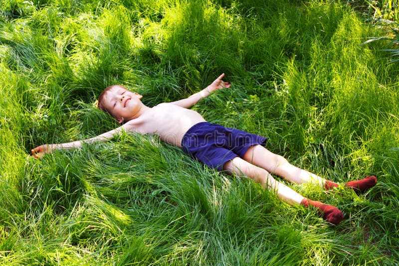 The Boy Lays on a Green Grass. Stock Image - Image of person, people ...