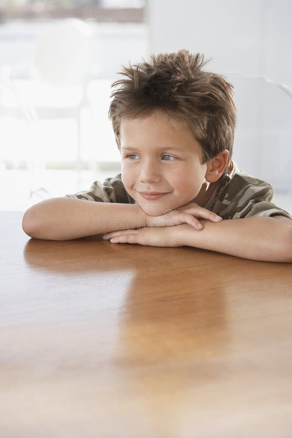 Boy Leaning on Wooden Dining Table Stock Photo - Image of indoors ...