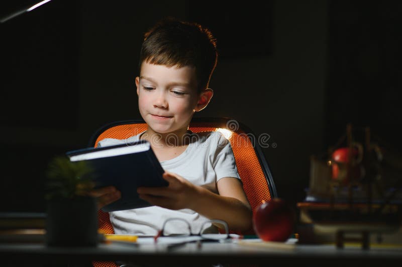 Boy Learn Lessons in the Home Setting at the Table in the Light of a ...