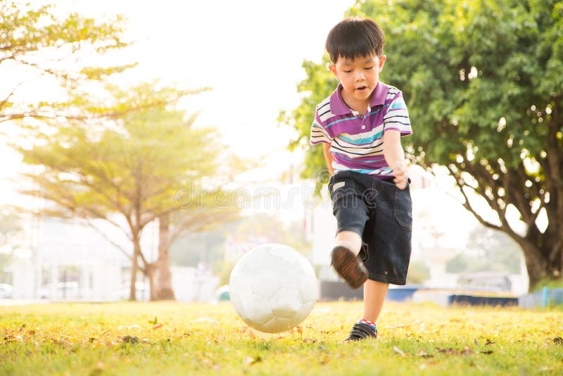 Boy Learning Kick Ball at the Park in the Evening Stock Photo - Image ...