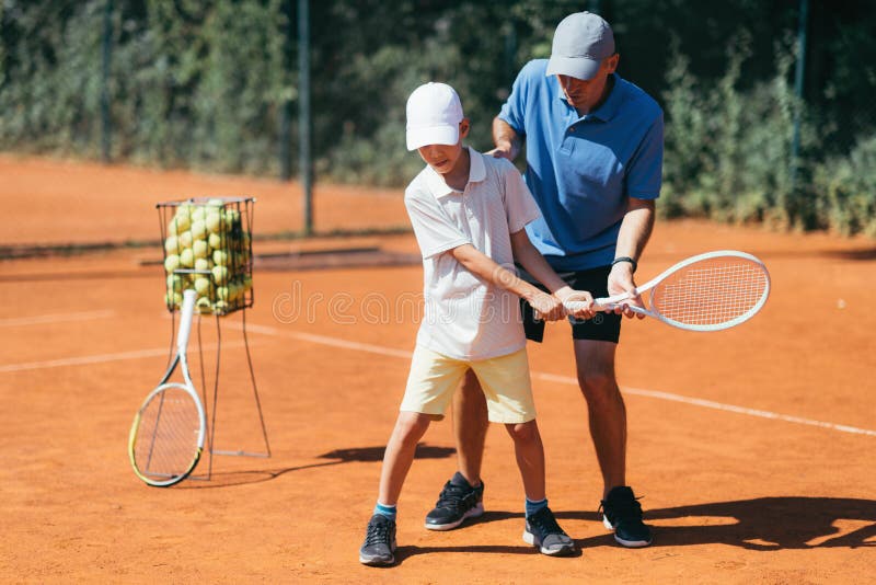 Boy Learning To Play Tennis Stock Image - Image of instructor ...