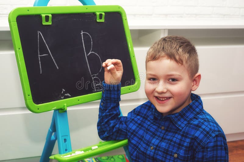 The Boy is Learning To Read and Write . the Child Learns the Alphabet ...
