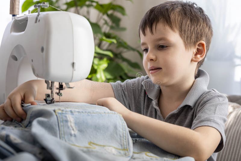 A Boy Learns To Sew on a Sewing Machine. Stock Image - Image of ...