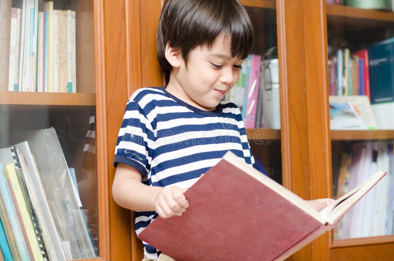 Boy in Library Holding Book Studying Stock Photo - Image of shelf ...
