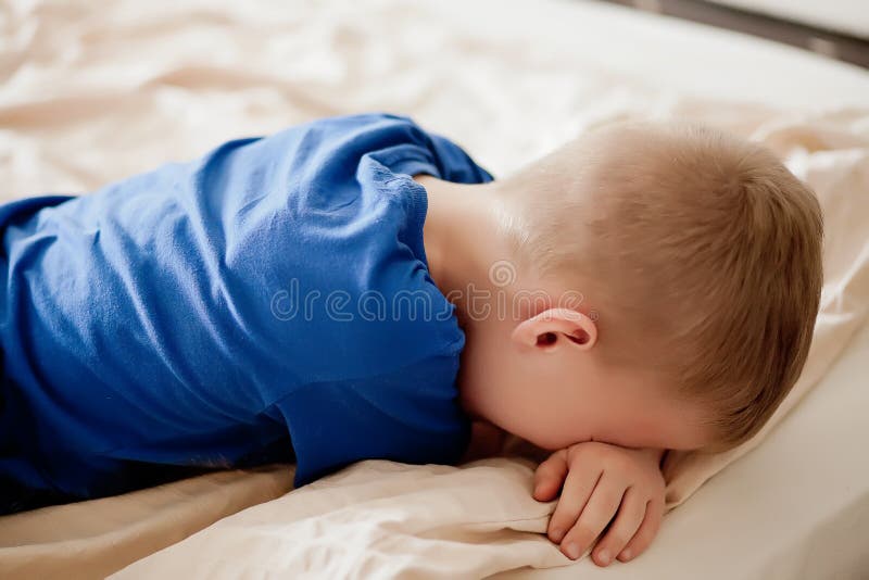 The Boy Lies on the Bed with His Back Turned and Cries Stock Photo ...