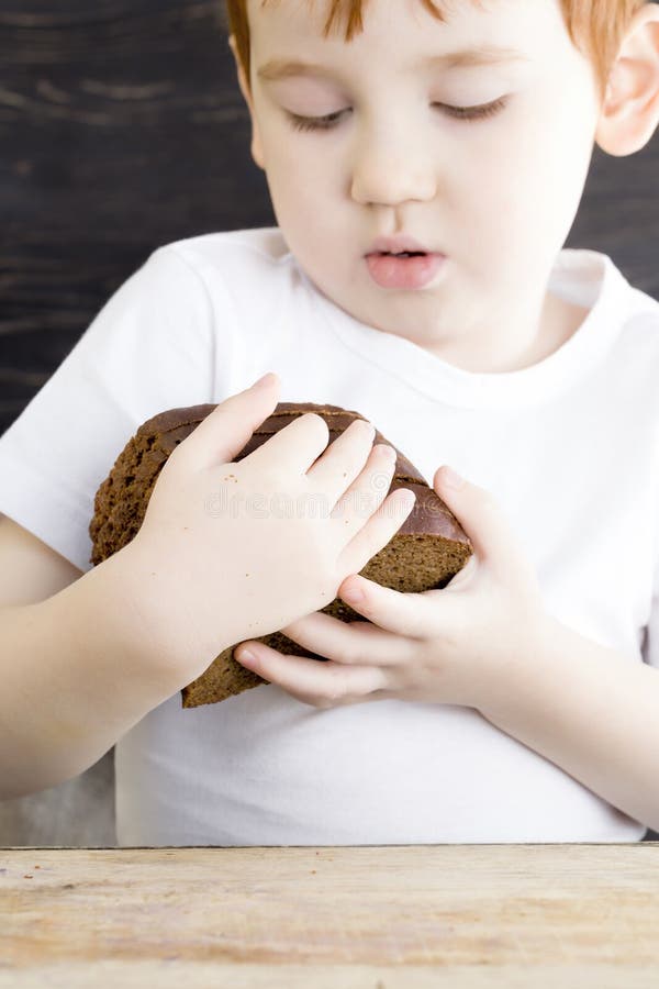 Boy with a loaf of bread stock photo. Image of redhaired - 223269640