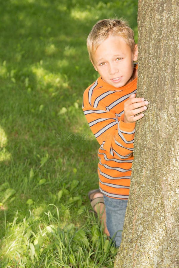 Boy Looking from Behind a Tree Stock Photo - Image of sandals, look ...