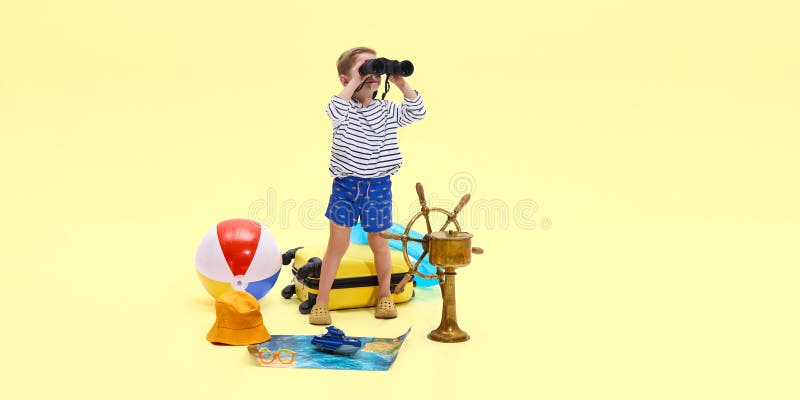 Boy Looking through Binoculars Ahead, Surrounded by Travel Props ...