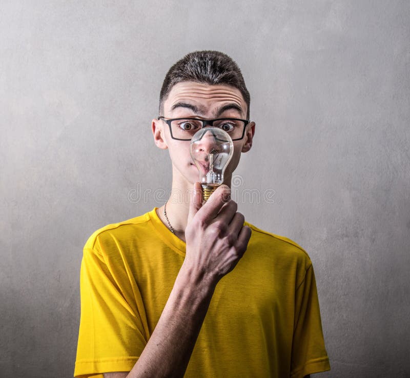 Boy Looking Curiously at a Lightbulb Stock Photo - Image of light ...