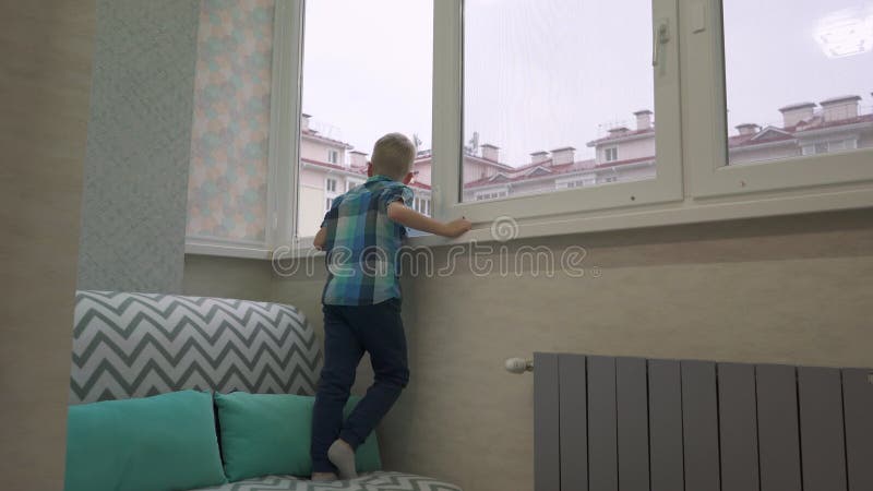 Boy Looking Out the Window Waiting for Parents at Home Alone Stock ...