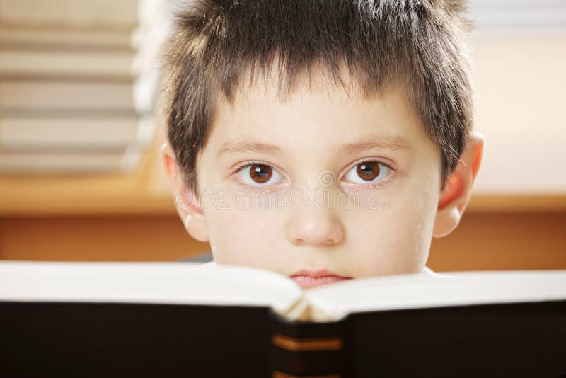 Boy looking over book stock image. Image of desk, book - 26461735