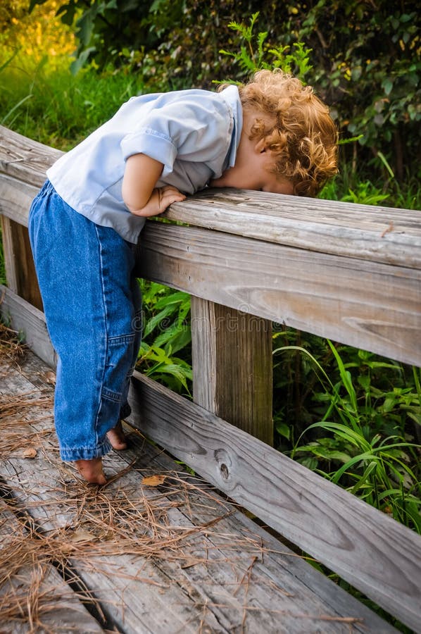 Boy Looking Over a Bridge stock photo. Image of cute - 103234050