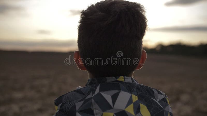 Boy Looks into the Distance at Sunset Back View, Outdoors Stock Video ...