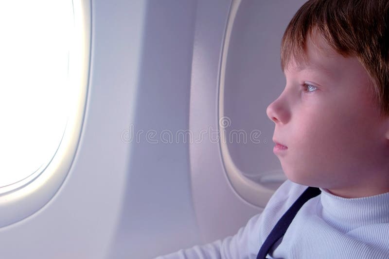 Boy Looks Out the Window while Flying in an Airplane. Stock Photo ...