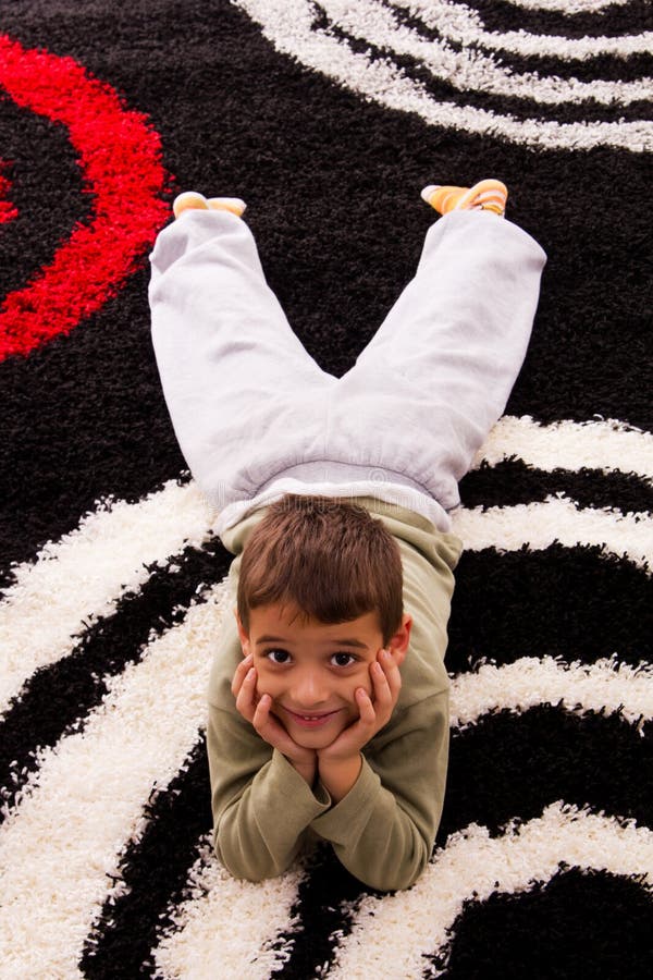 Boy lying on the carpet stock photo. Image of human, floor - 25963676