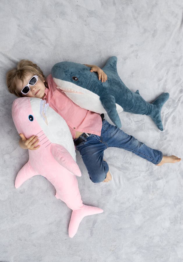 Boy Lying on the Floor in the Middle of Two Big Stuffed Shark Toys ...