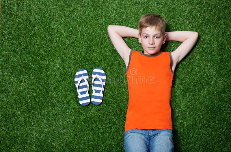 Boy Lying on Green Grass with Slippers Stock Image - Image of ...