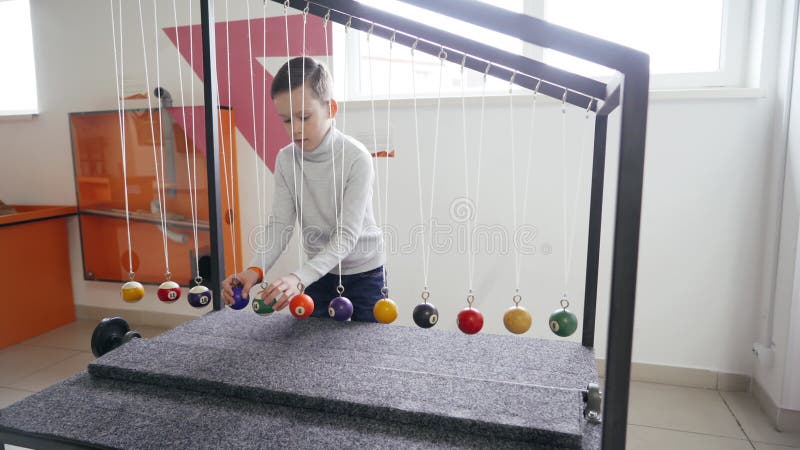 Boy Makes an Experiment with Newton S Pendulum. the Concept of Physics ...