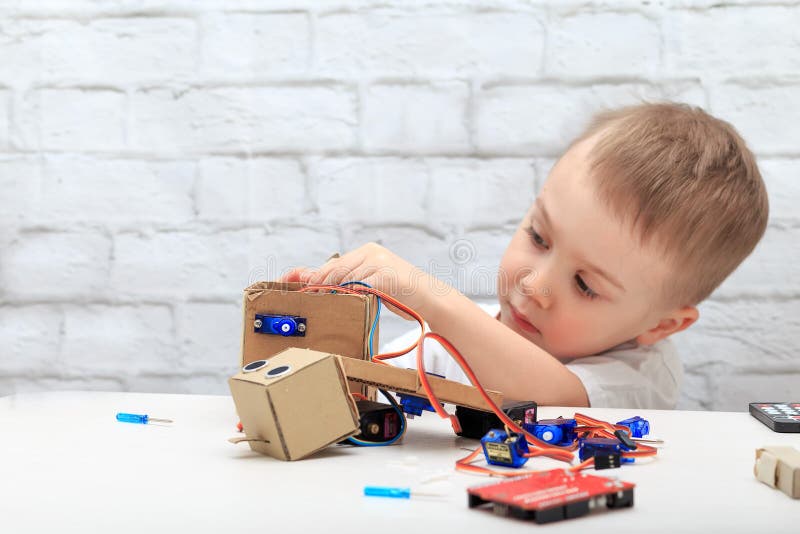 Little Boy Plays with the Robot at Home. Child Exploring Robot Stock ...