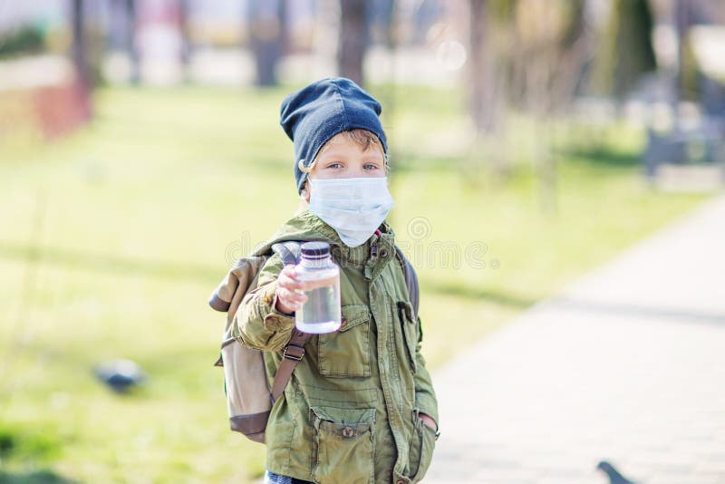 A Boy in Mask Holds a Bottle of Water in Hand Stock Image - Image of ...