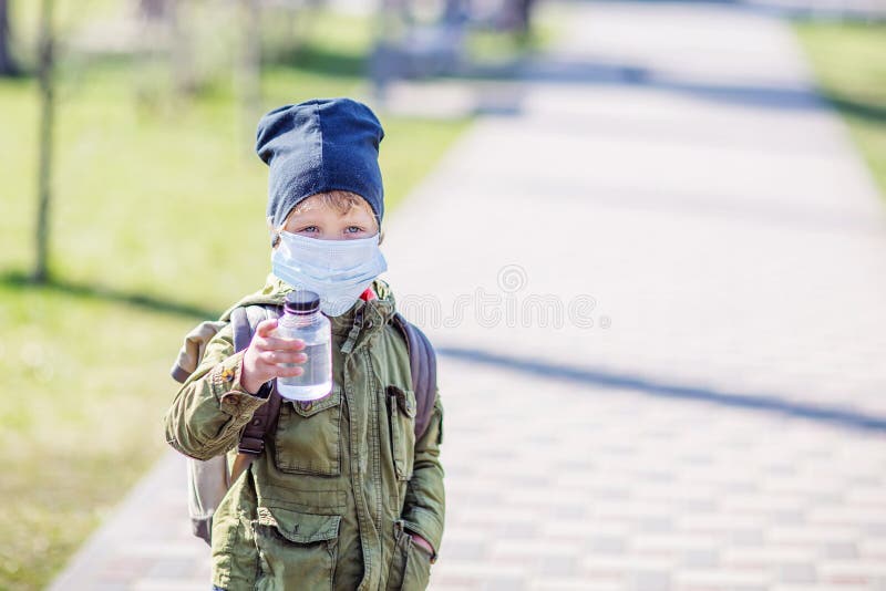 A Boy in Mask Holds a Bottle of Water in Hand Stock Image - Image of ...