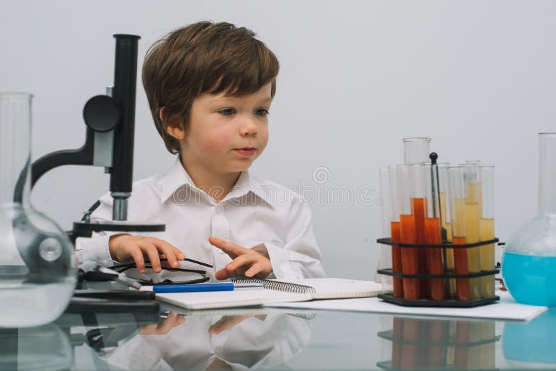 The Boy with a Microscope and Various Colorful Flasks on a White ...