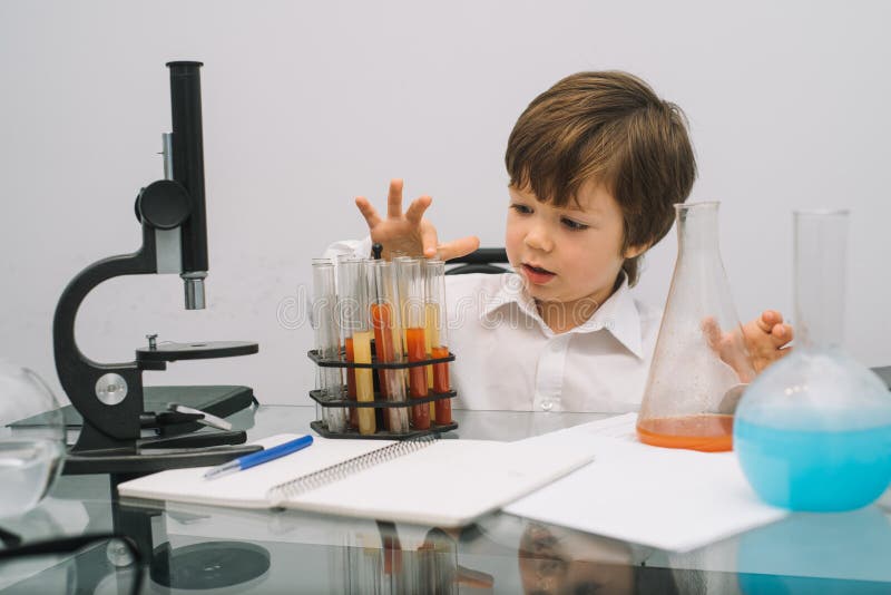 The Boy with a Microscope and Various Colorful Flasks on a White ...