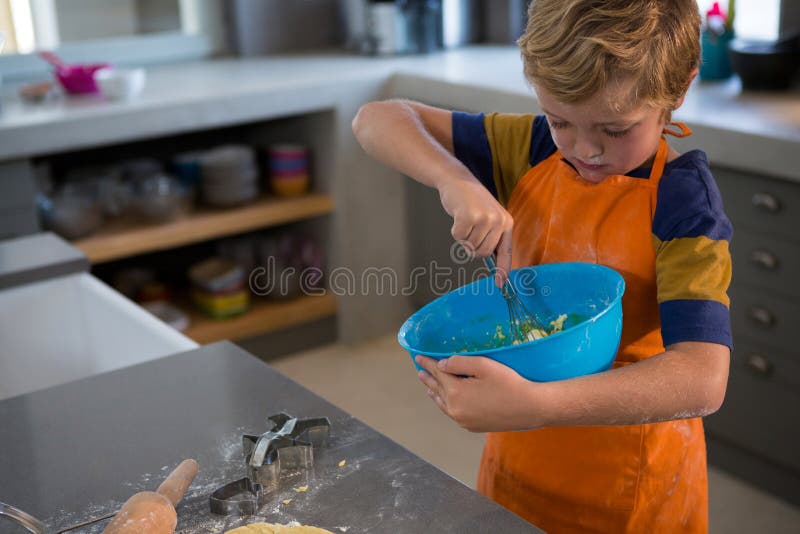 Boy mixing batter in bowl stock image. Image of clothing - 97402061