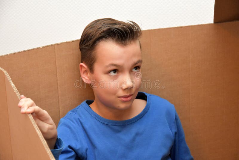 Boy in moving box stock photo. Image of teenager, moving - 65802846
