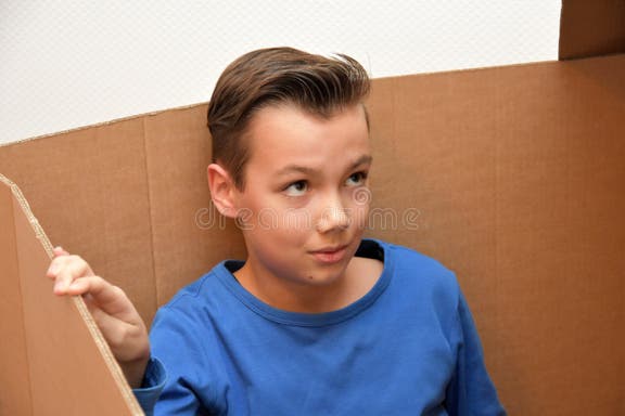 Boy in moving box stock photo. Image of teenager, moving - 65802846
