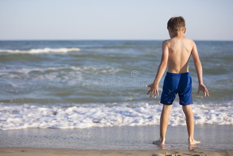 A Boy Near the Sea is Considering the Waves. Stock Photo - Image of ...