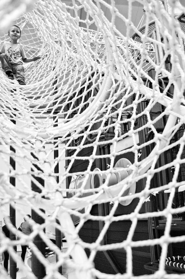 Boy in Net Sleeve of Amusement Park Climbing Facility Stock Photo ... Boy in Net Sleeve of Amusement Park Climbing Facility Stock Photo ...