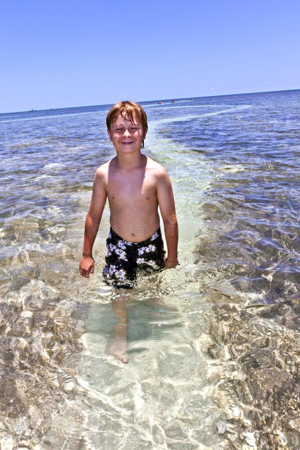 Boy in the ocean stands stock image. Image of pleasure - 37041793