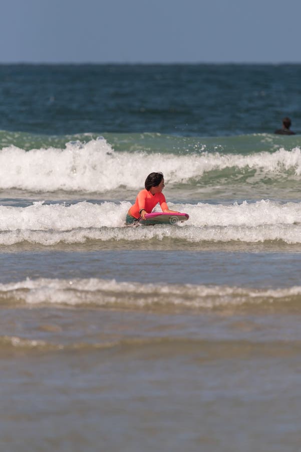 Boy with Orange Equipment and Bodyboard Practices in the Waves of ...