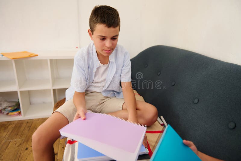 Boy Organizing Colored Notebooks Stock Image - Image of casual, couch ...