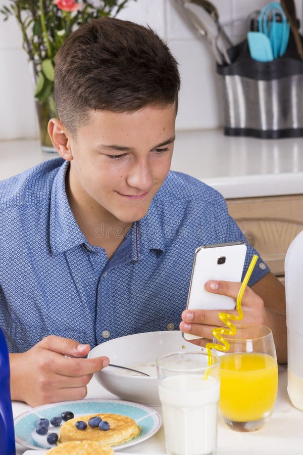Boy with Phone Having Breakfast in Kitchen Stock Photo - Image of ...