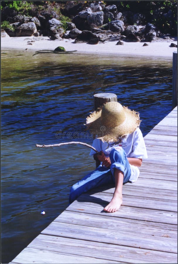 Boy Sitting On A Dock Waiting Stock Photo - Image of male, watching ...
