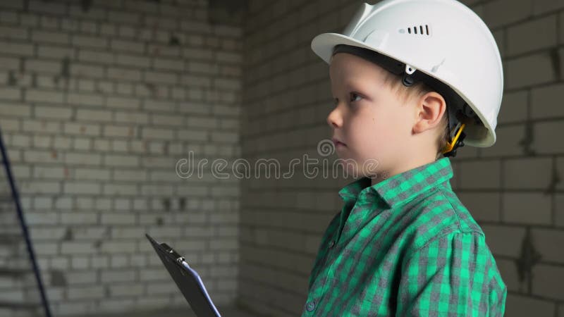 A Boy with a Plan in His Hands Looks at the Work Done and Checks the ...
